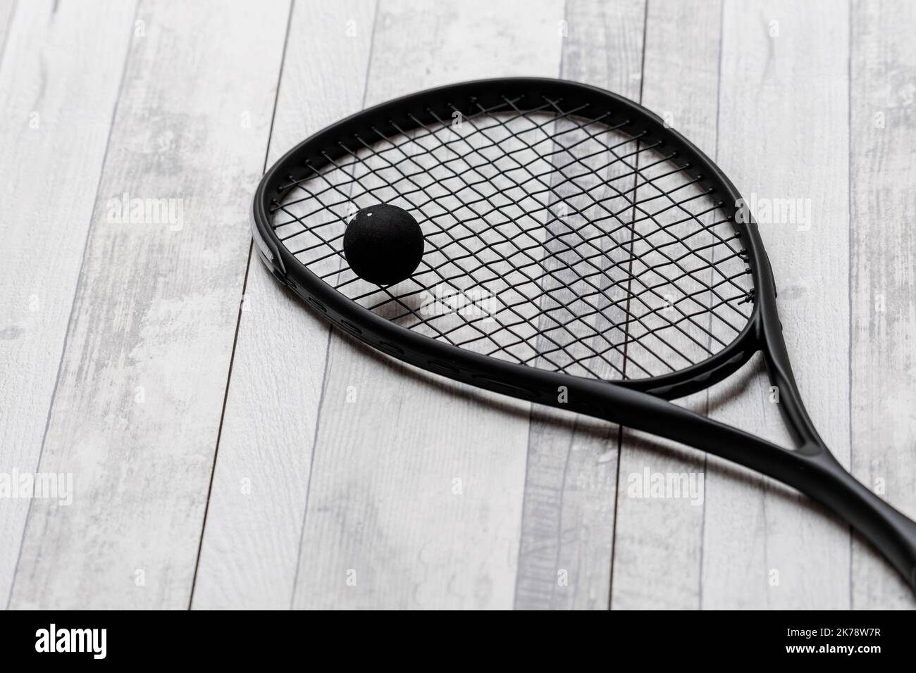 Black squash racket and ball on grey court. Horizontal sport theme ...
