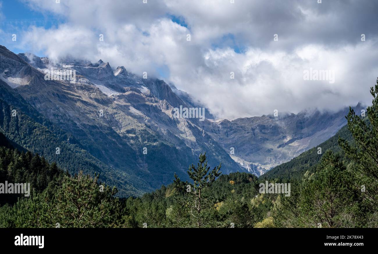 magnificent view of a long glacial forested valley through cloud topped ...