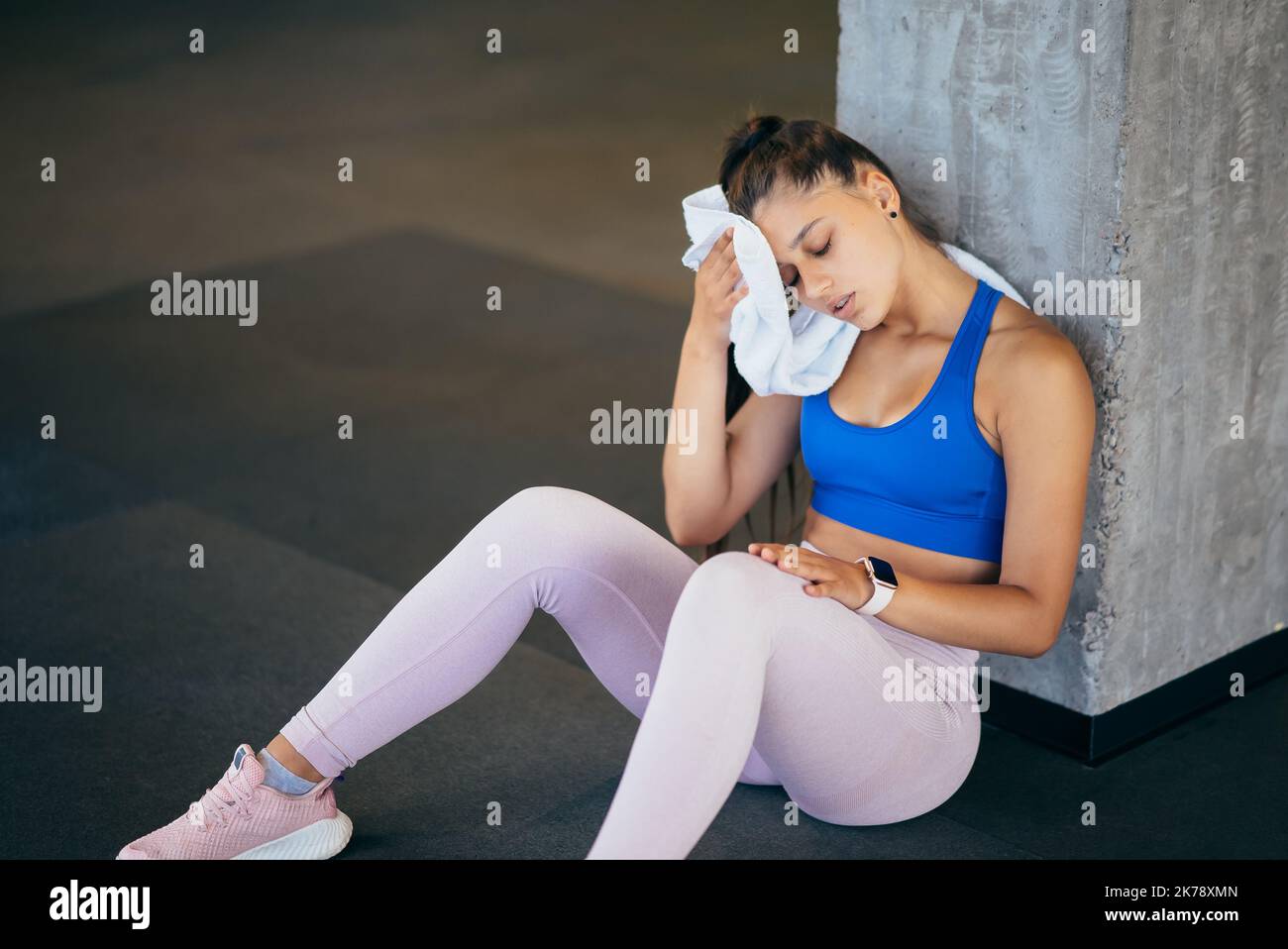 Healthy young female sitting relaxed after training in gym Stock Photo ...