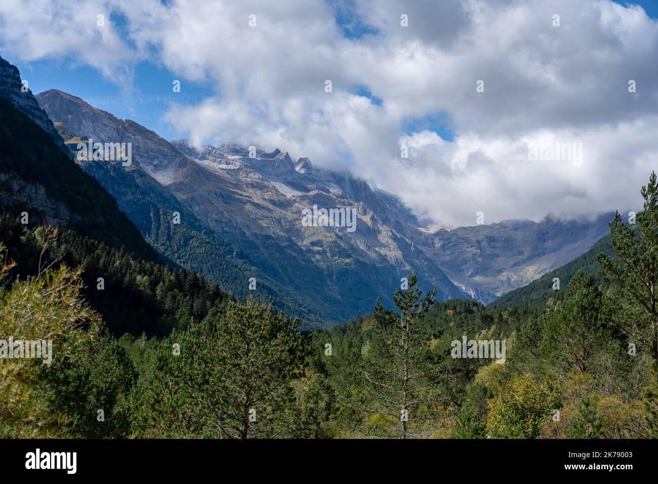 magnificent view of a long glacial forested valley through cloud topped ...