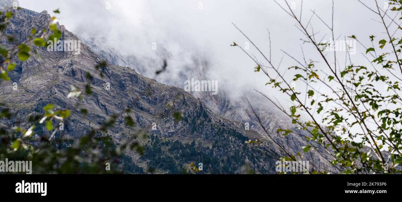 magnificent view of a long glacial forested valley through cloud topped ...