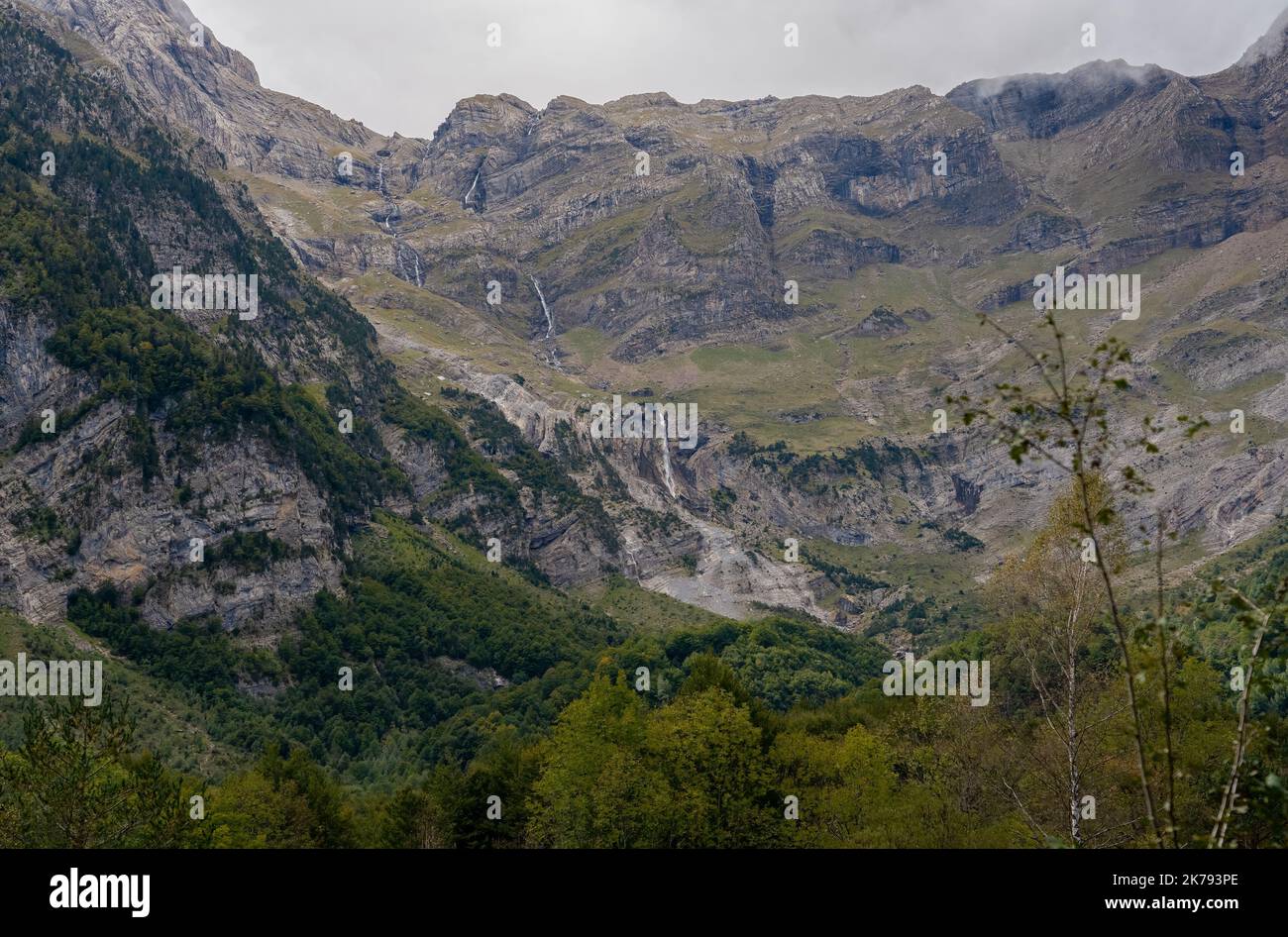 magnificent view of a long glacial forested valley through cloud topped ...