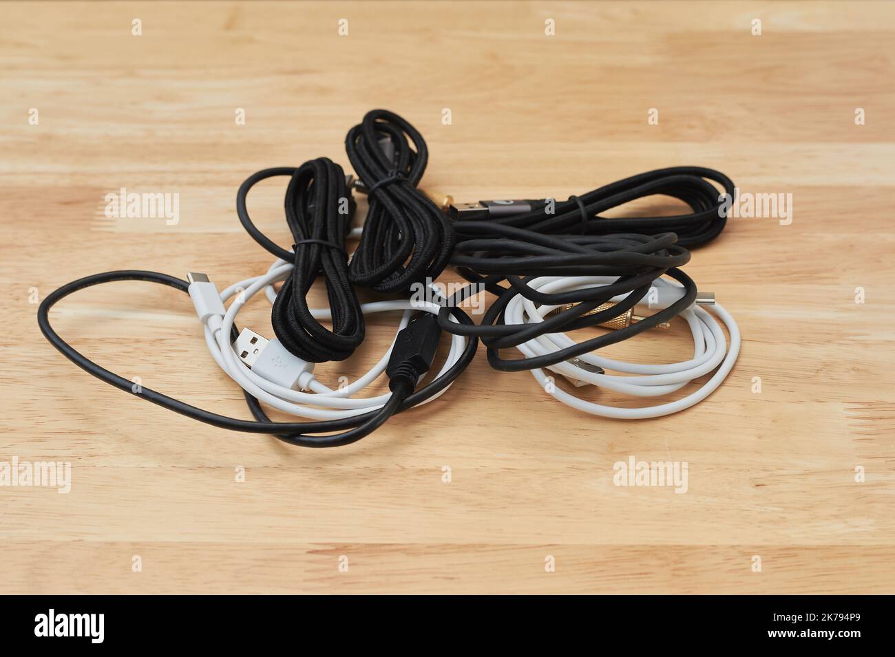 Electrical and charging cables of various kinds lying on a work bench ...