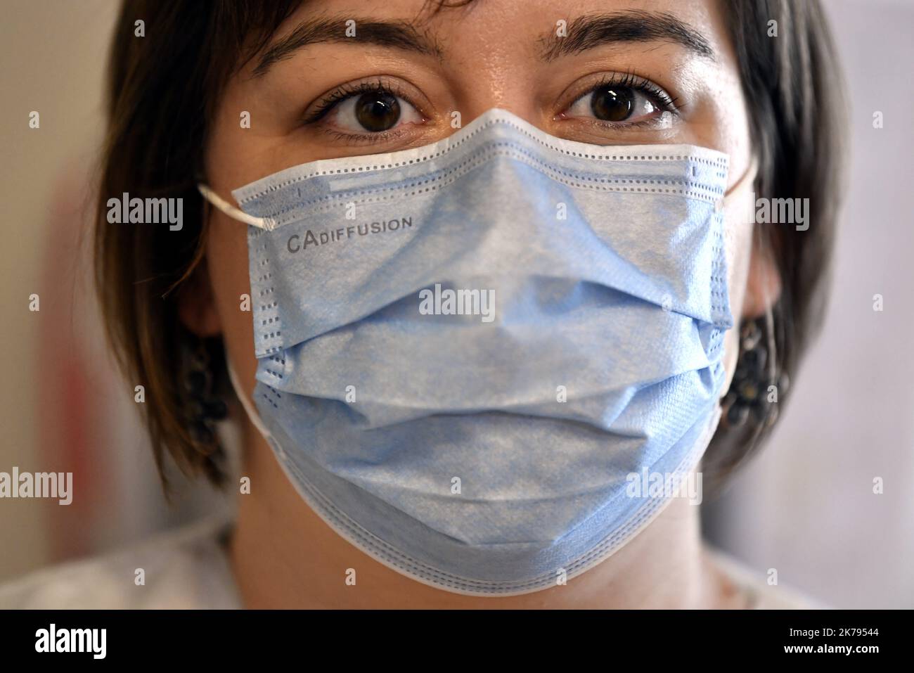 A member of hospital staff wears a protective mask in a corridor ...