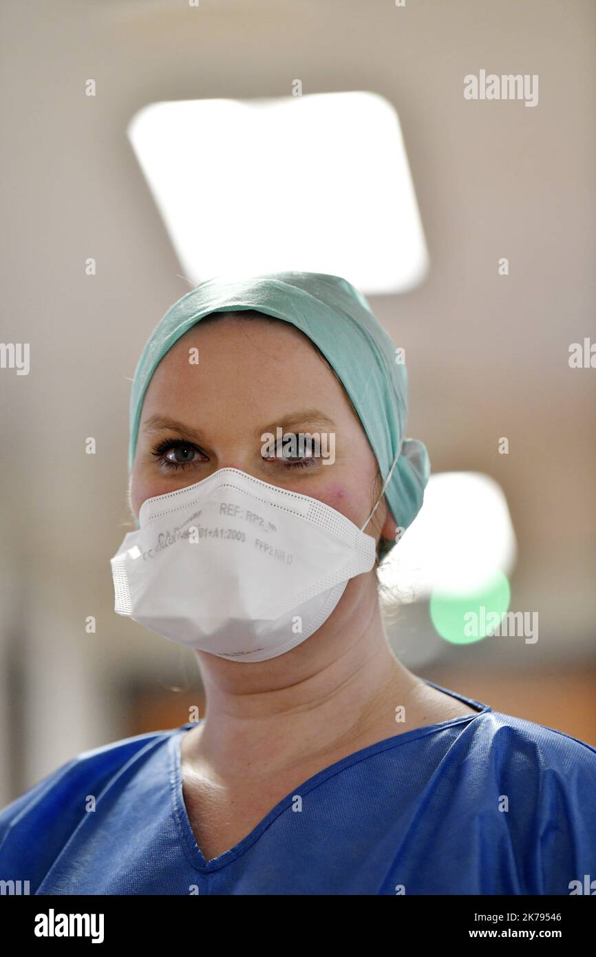 A member of hospital staff wears a protective mask in a corridor ...