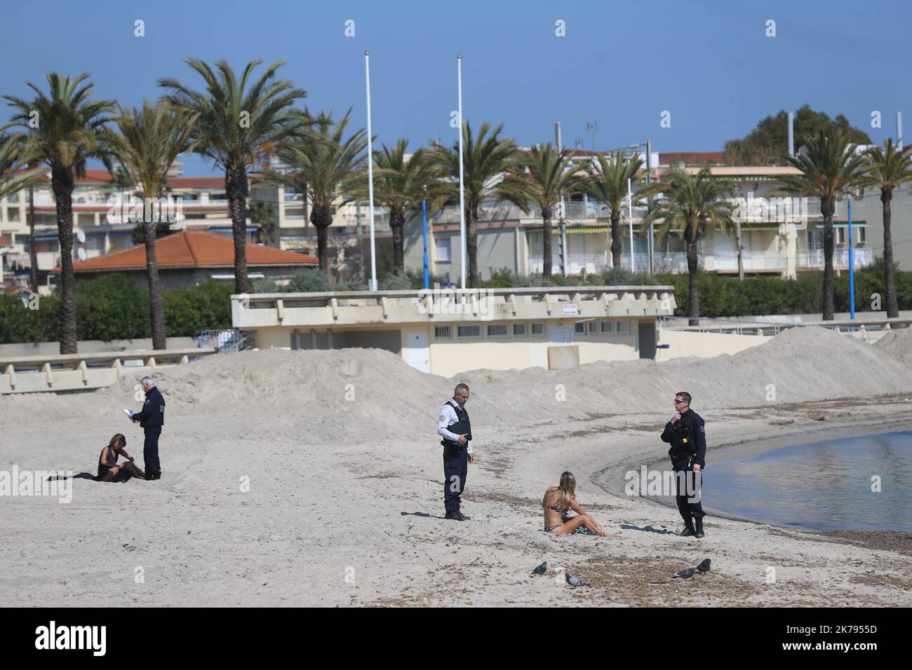 Police approach women sitting on the French Riviera beach despite a ban ...