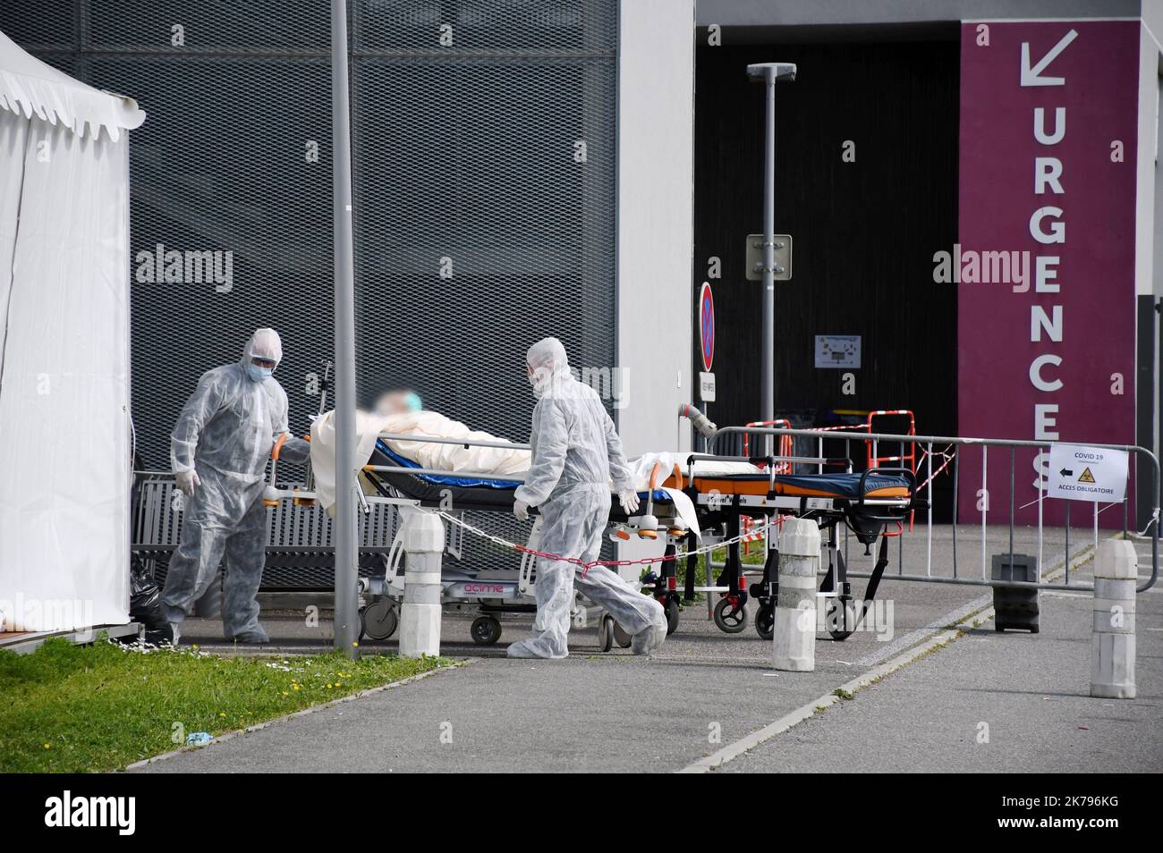 Paramedics in a protective suit prepares to drop a patient off at the ...
