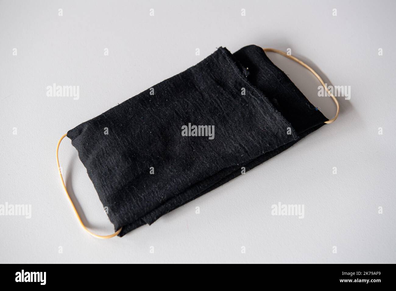 Covid-19 / A woman creates her own mask with a textile square and 2 ...