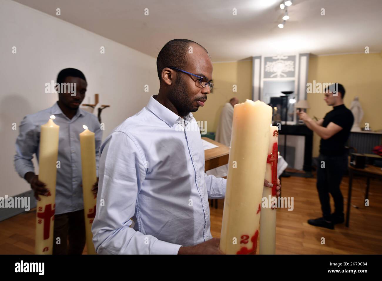 A lit Paschal candle and Christ on his Cross, and candles in the ...