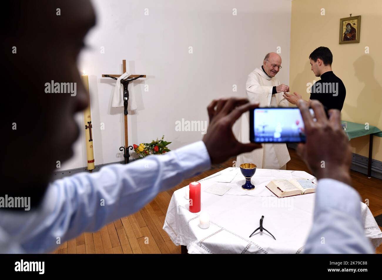 A lit Paschal candle and Christ on his Cross, and candles in the ...