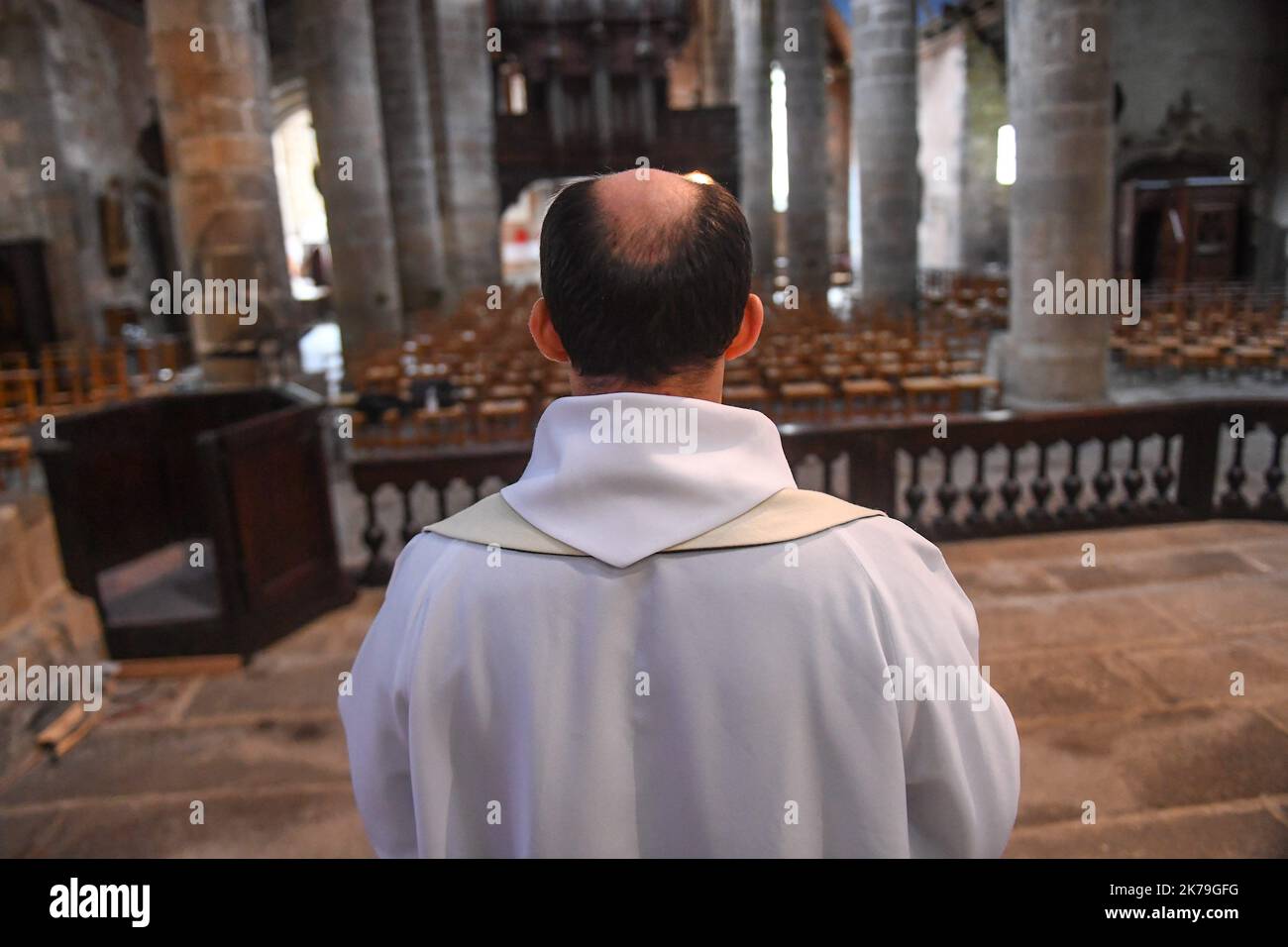 A priest stands in an empty church in the French town of Morlaix Stock ...