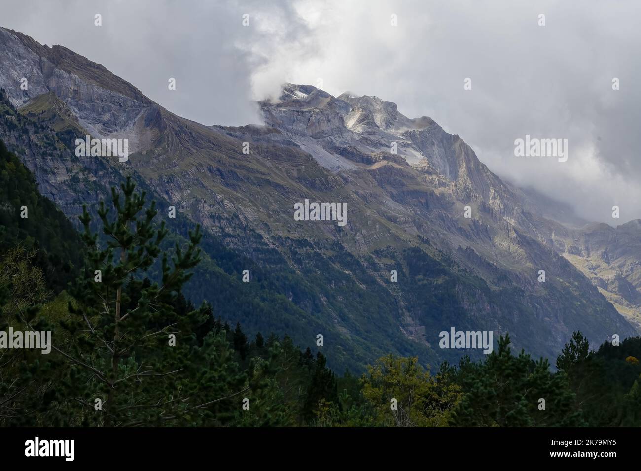 view along a glacial forest lined valley to a massive mountainous ...