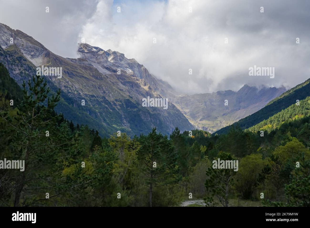 view along a glacial forest lined valley to a massive mountainous ...