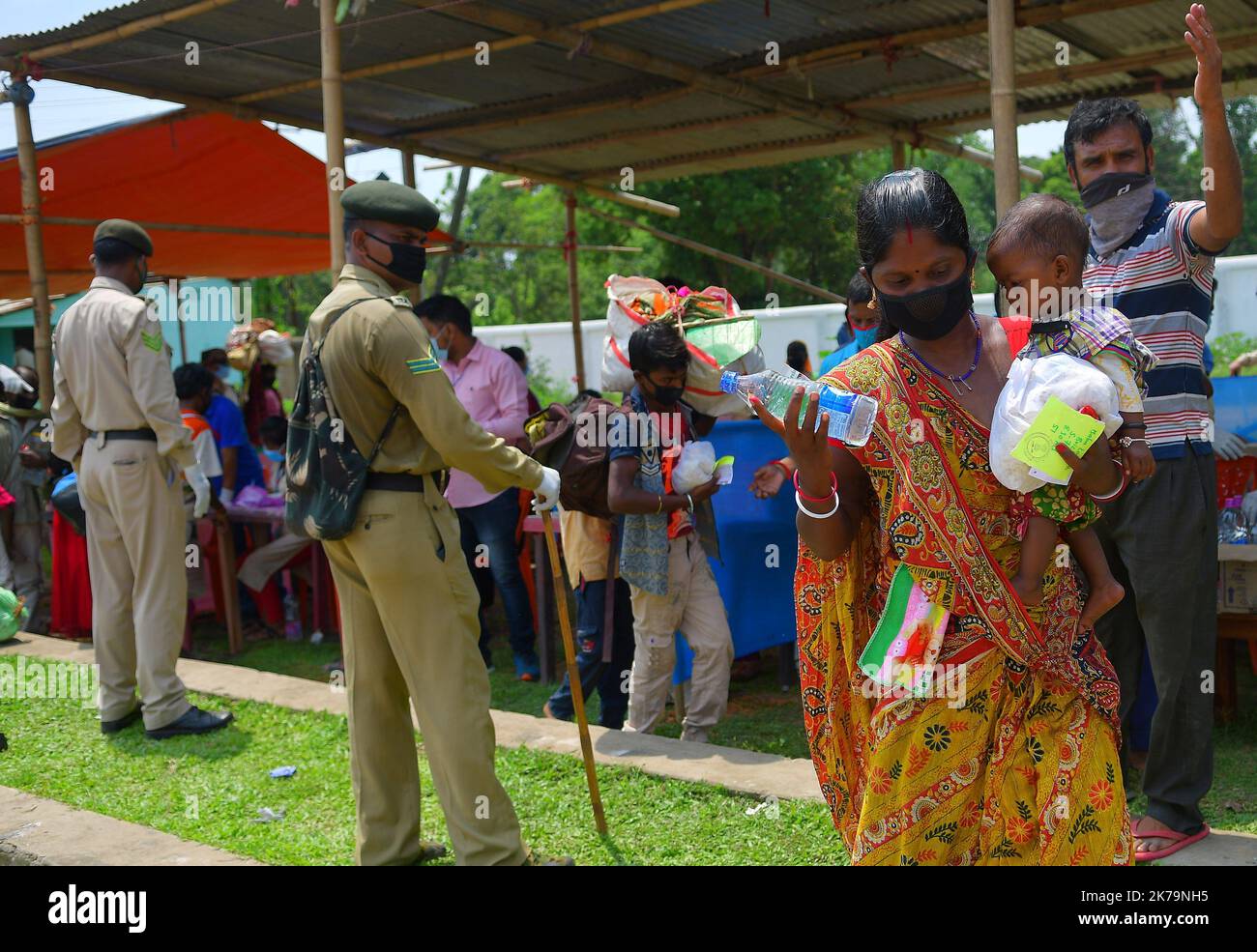 India / Tripura / Agartala - Migrant workers and family members line up to show their papers and ...