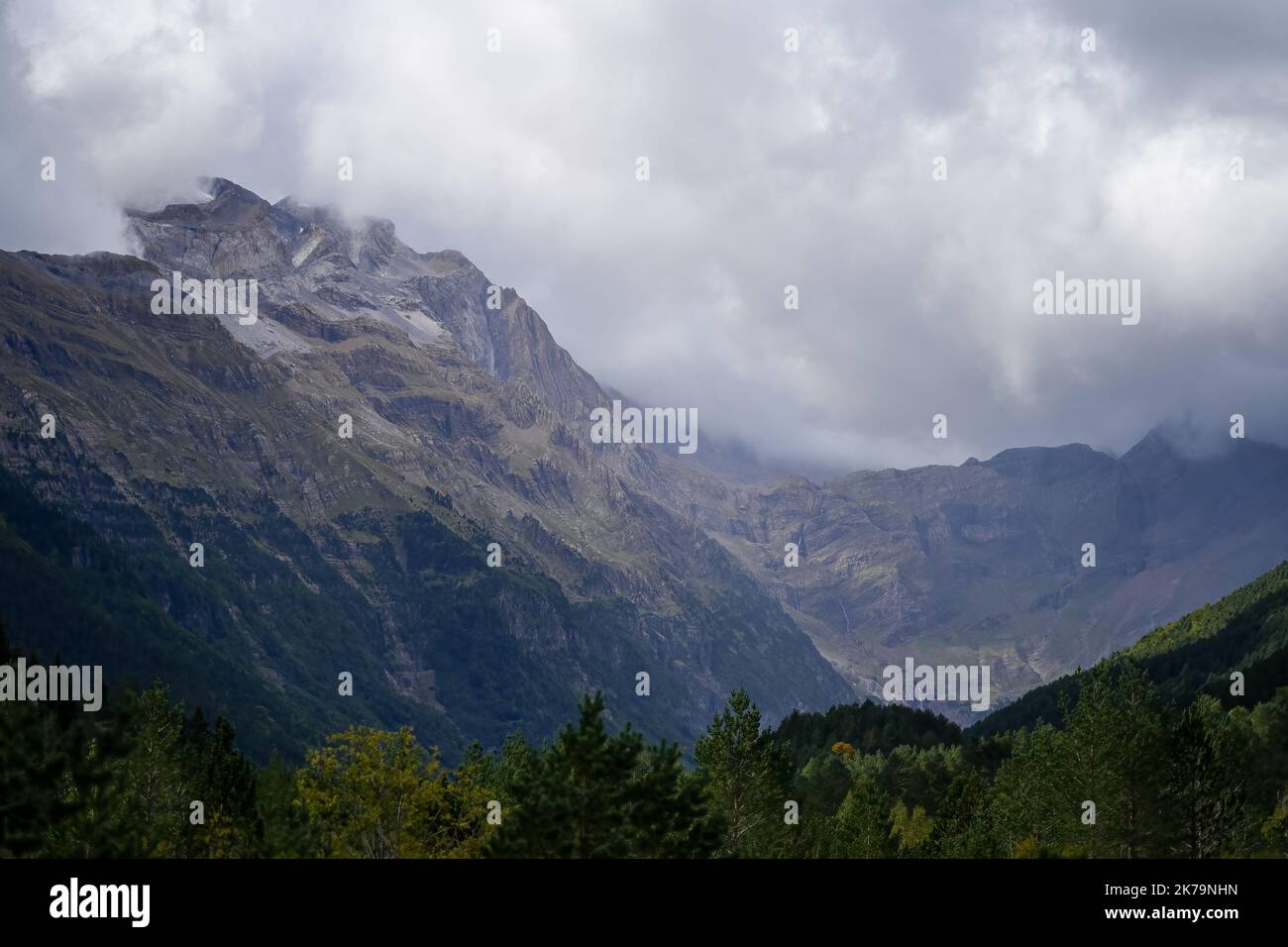 view along a glacial forest lined valley to a massive mountainous ...