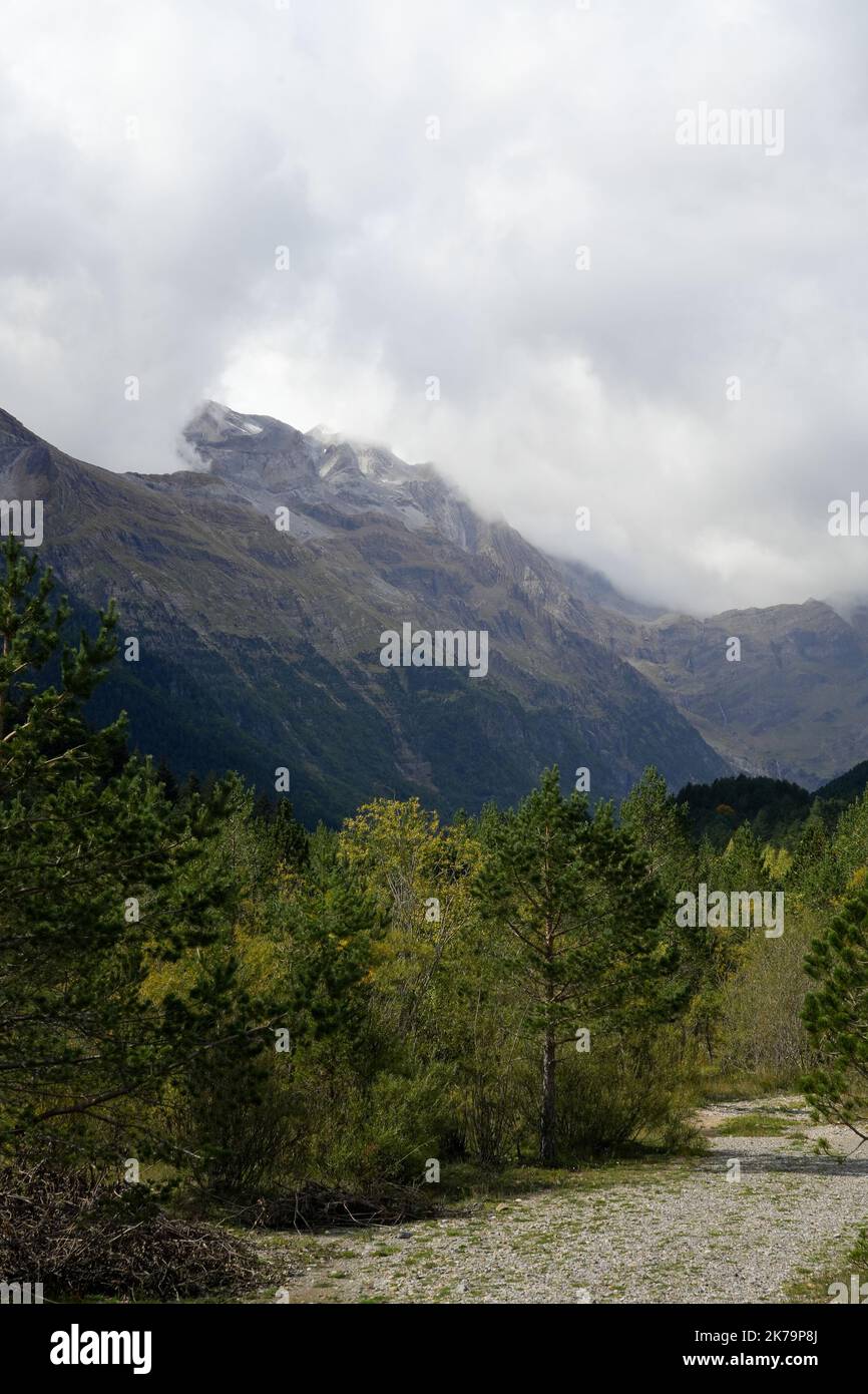 view along a glacial forest lined valley to a massive mountainous ...