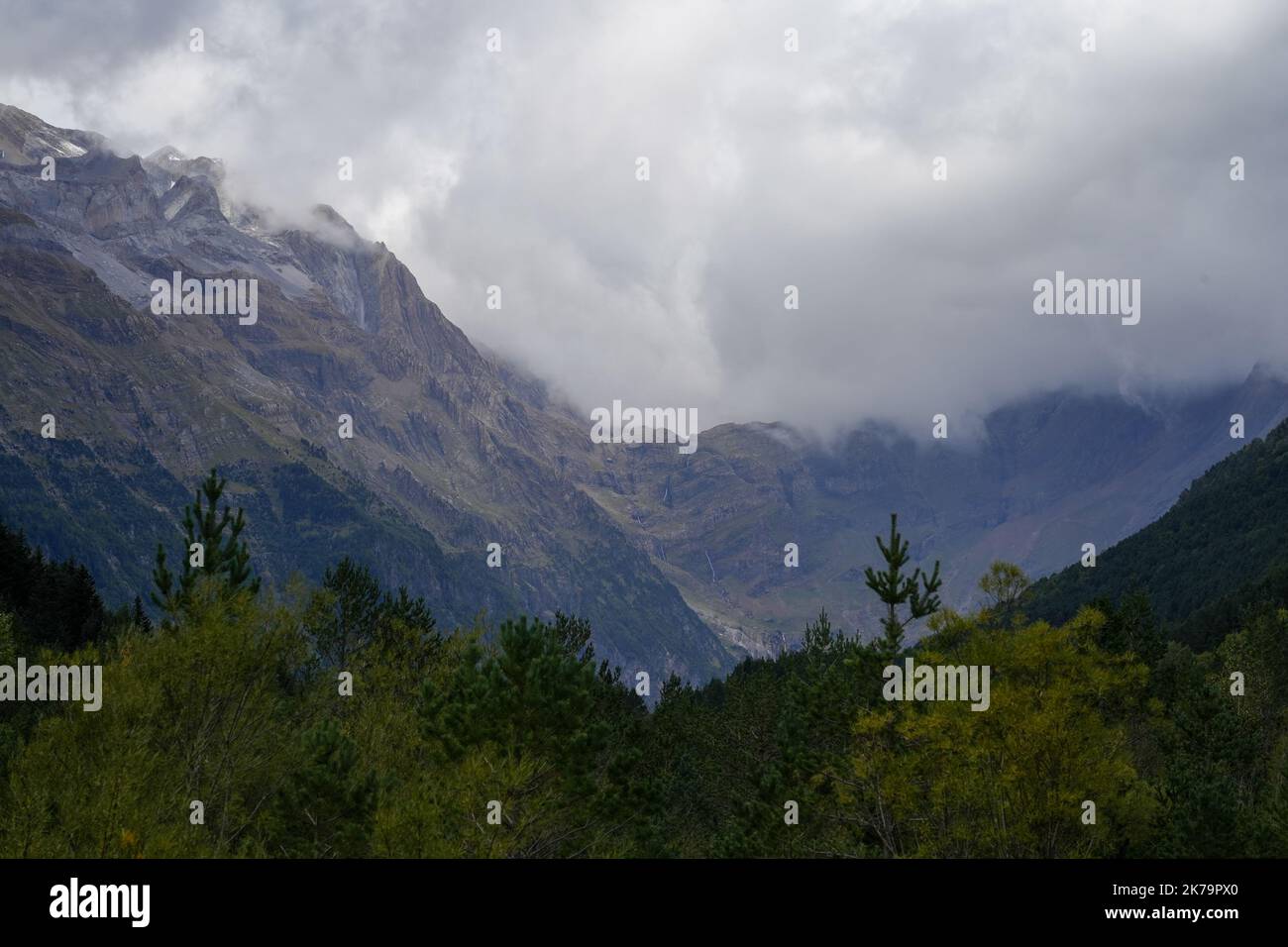 view along a glacial forest lined valley to a massive mountainous ...