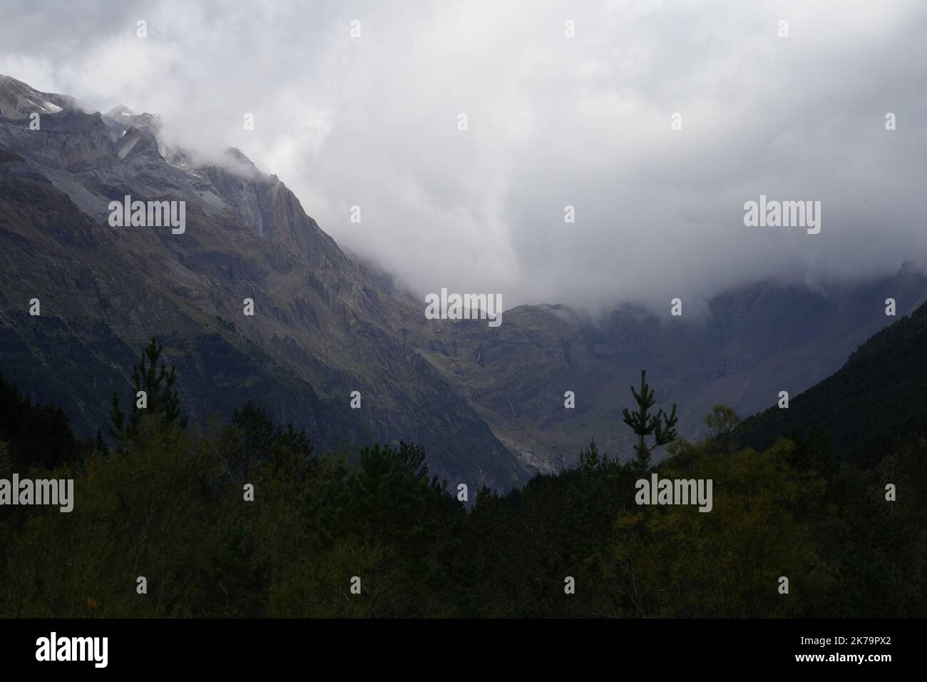view along a glacial forest lined valley to a massive mountainous ...