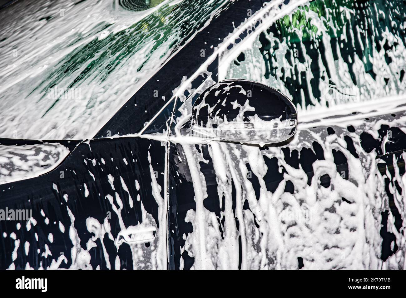 Hand washing the car with foam soap. The car is covered in foam Stock ...