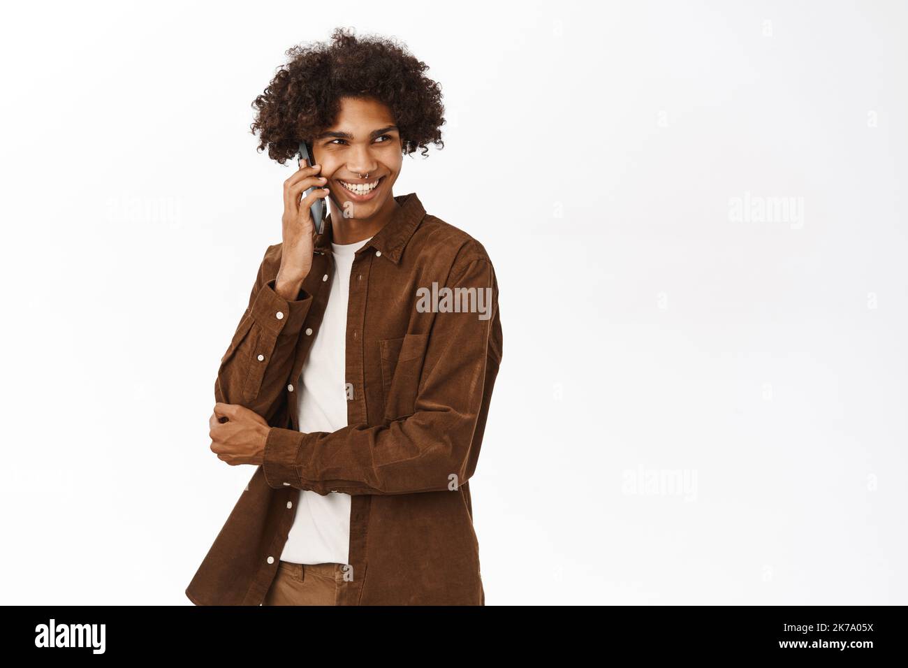 Portrait of hispanic guy talking on mobile phone, chatting or calling ...
