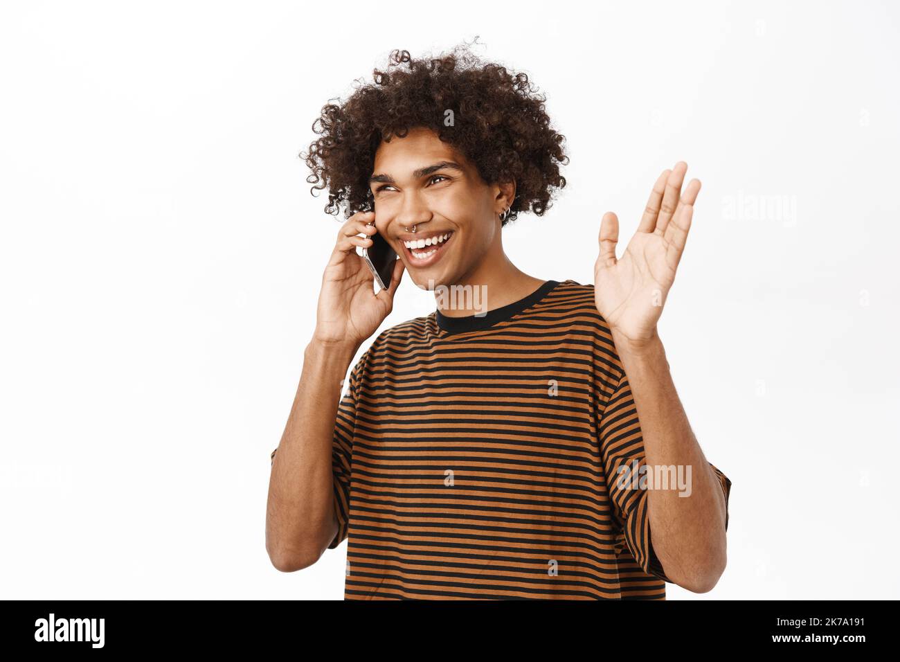 Portrait of young man chatting on phone, talking on smartphone and ...