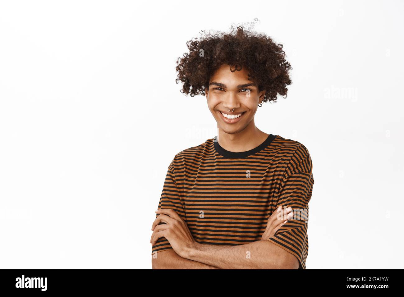 Portrait of handsome hispanic male model with curly hair, smiling and ...