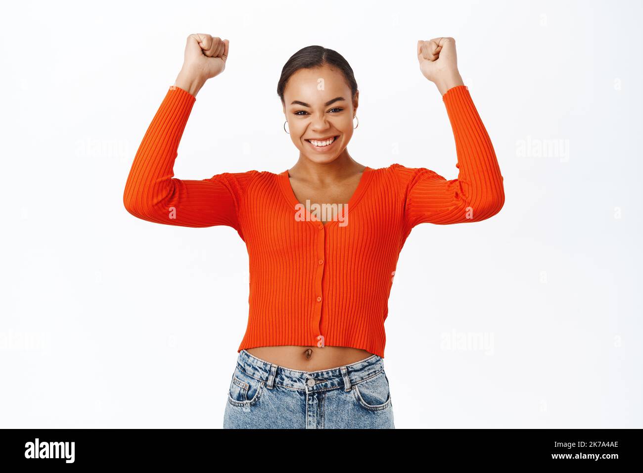 Hooray victory. Excited young woman winning, raising hands up and ...