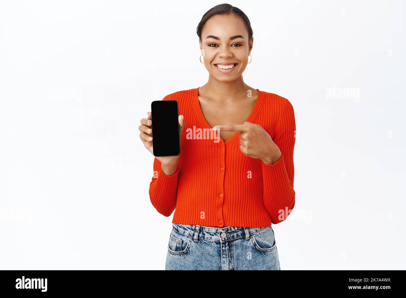 Portrait of woman pointing finger at mobile phone screen, showing ...