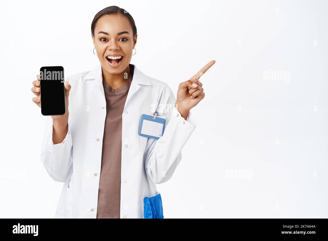 Female doctor shows mobile phone screen, pointing finger right at ...
