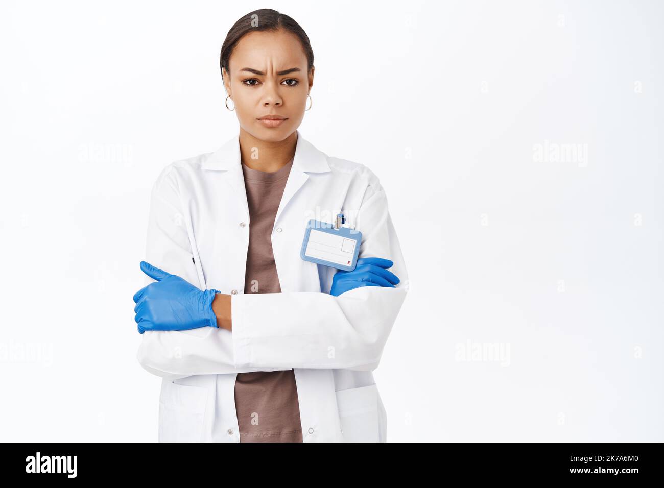 Confident medical doctor in gloves, cross arms on chest, standing over ...