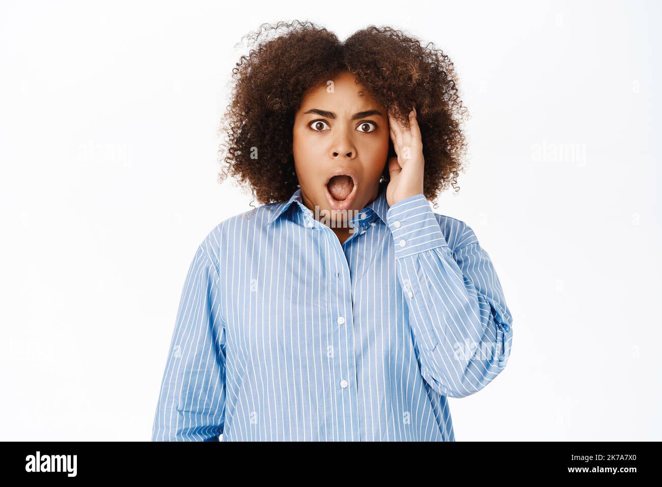 Portrait of black woman looking shocked and concerned at camera, gasps ...