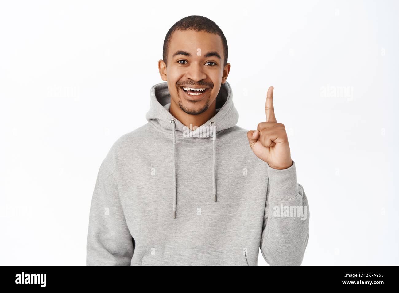 Happy smiling man pointing finger up at logo, showing advertisement or ...