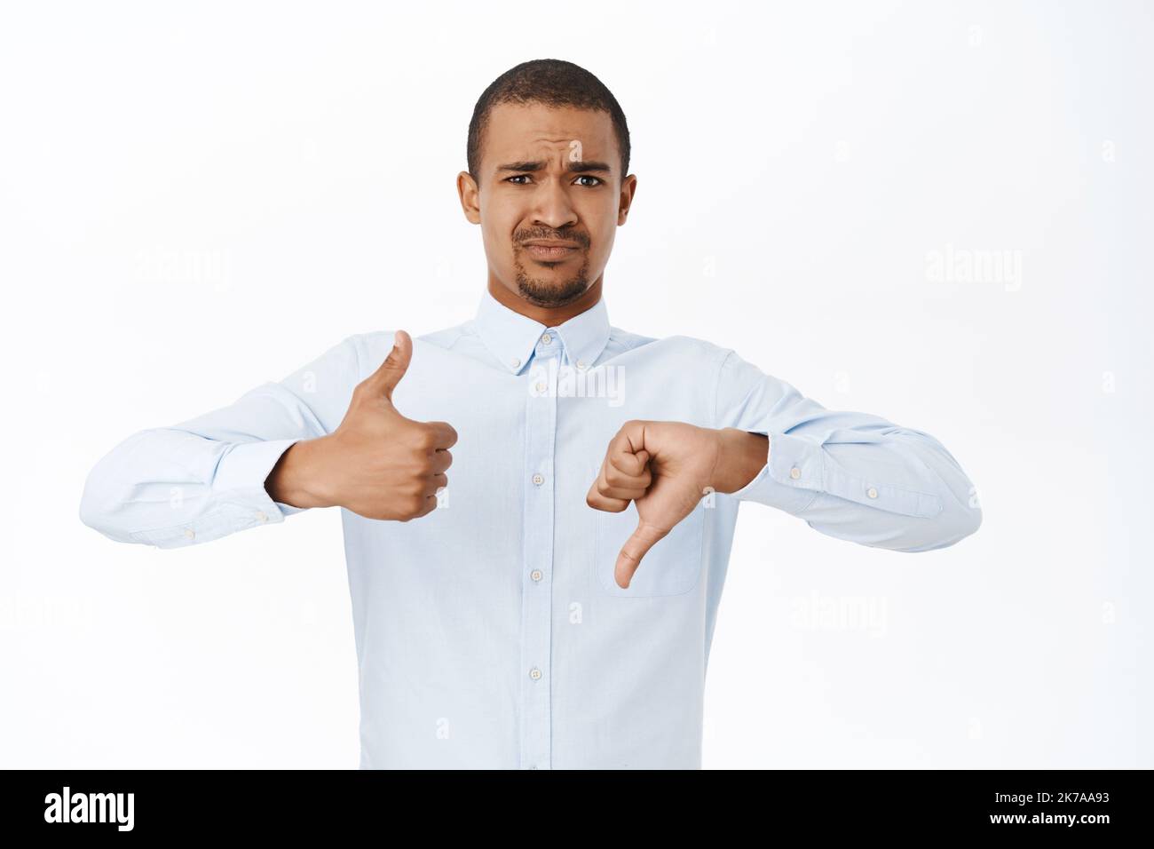 Like or dislike. Handsome man shows thumbs up and thumbs down, negative ...