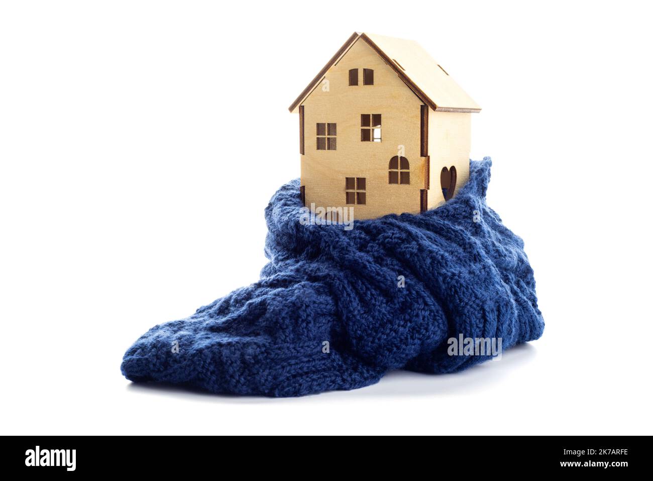 Wooden toy house is wrapped in a warm scarf isolated on white ...