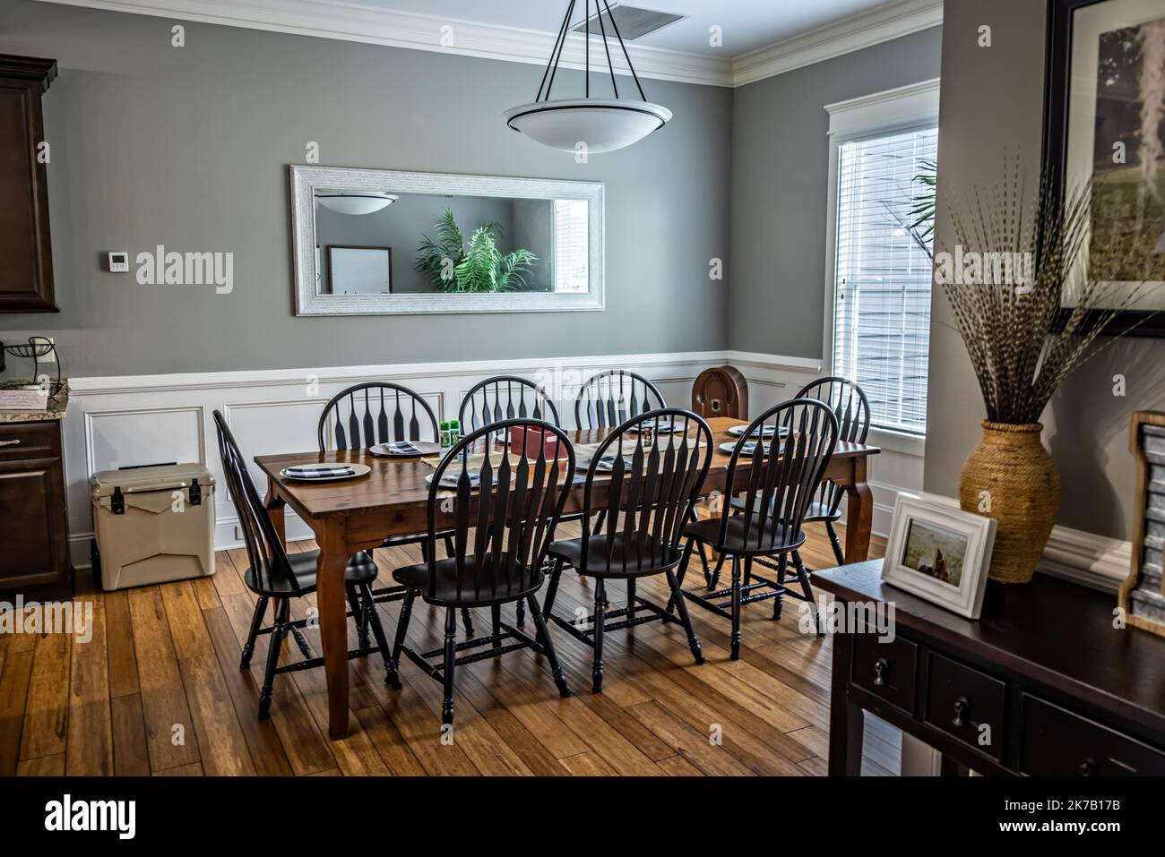 A large dining room with a simple farmhouse tabel and chairs, a window ...