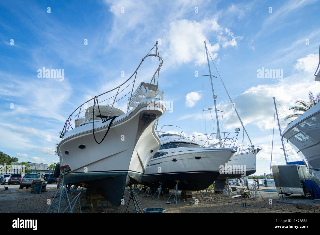 Yachts and sailboats sit in a Florida boatyard on a sunny afternoon ...