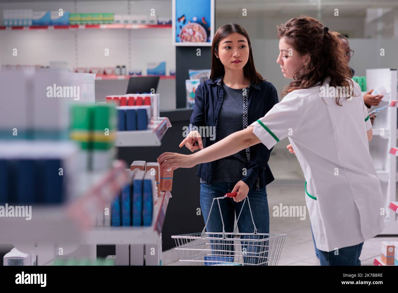 Helpful pharmacist woman taking SPF product out of shelves to ...