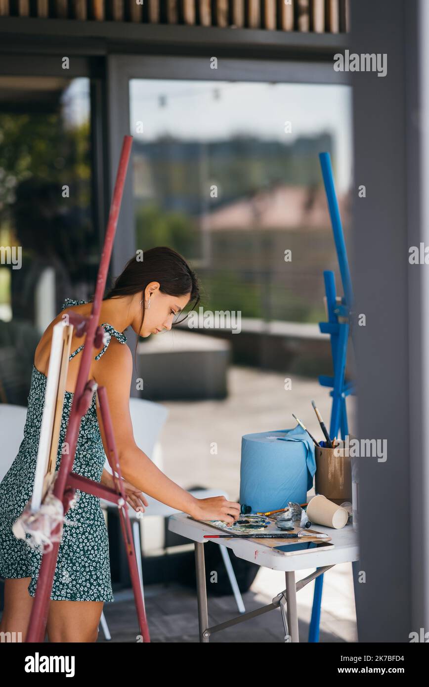 Young woman artist stands close table with a palette Stock Photo - Alamy