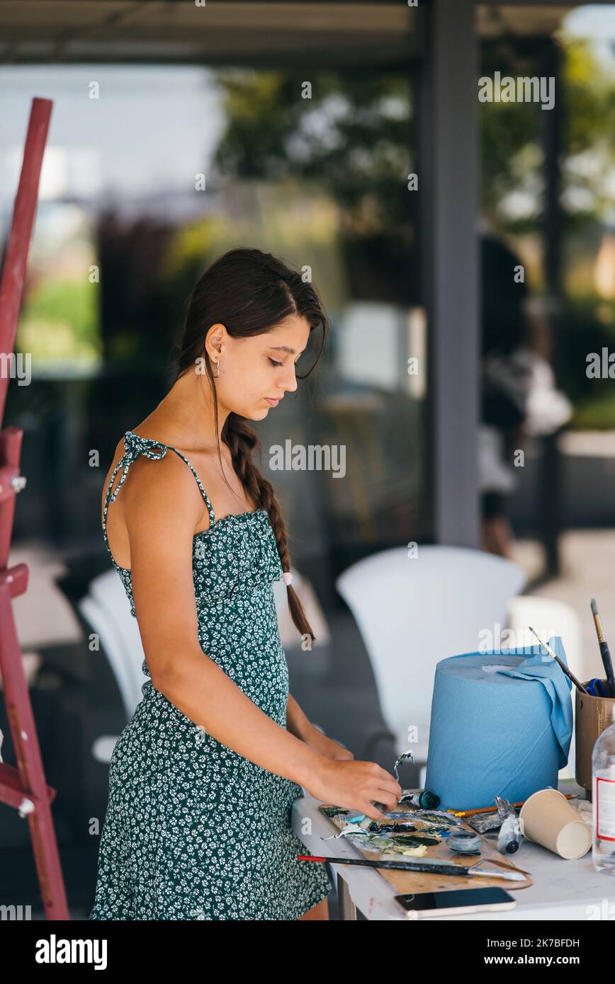 Young woman artist stands close table with a palette Stock Photo - Alamy