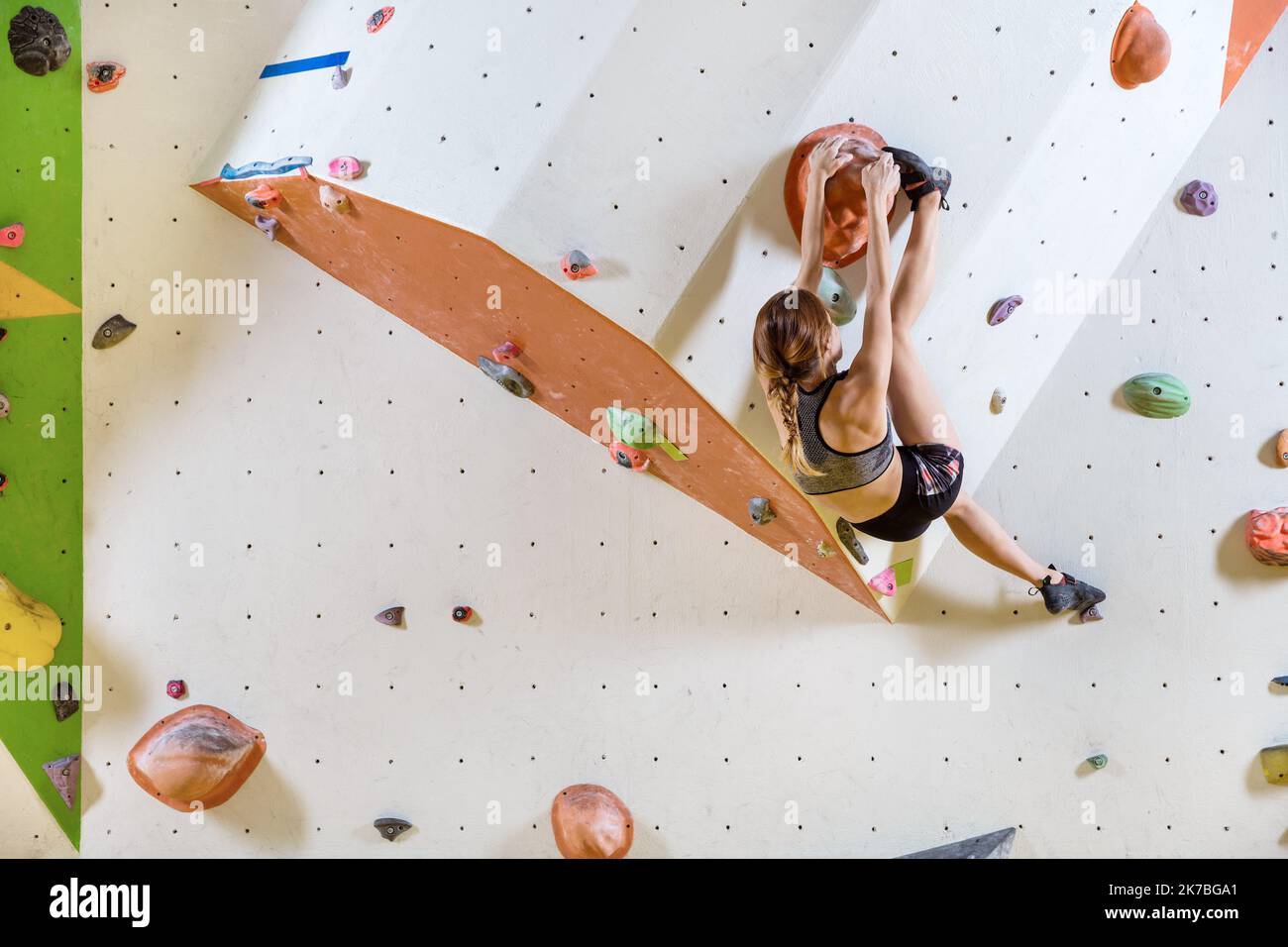 Young woman bouldering problem (route) in indoor climbing gym Stock ...