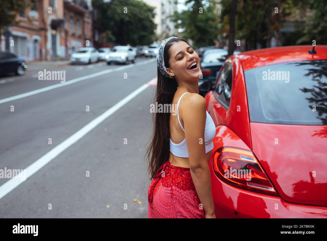 Portrait of pretty Caucasian woman standing against new red car Stock ...