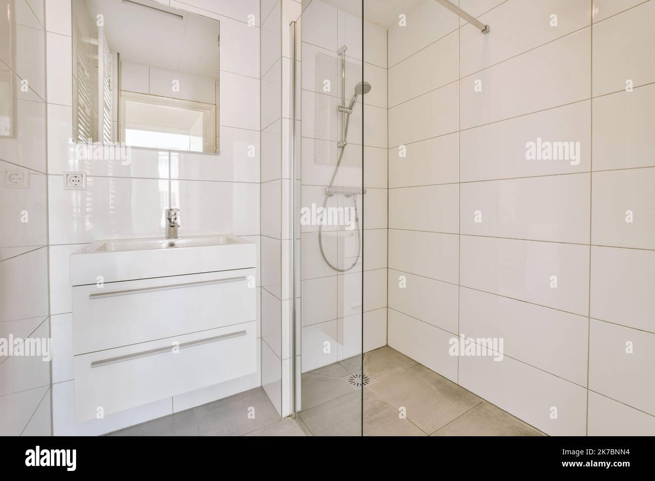 Sinks with mirrors and shower box with glass door in modern bathroom ...