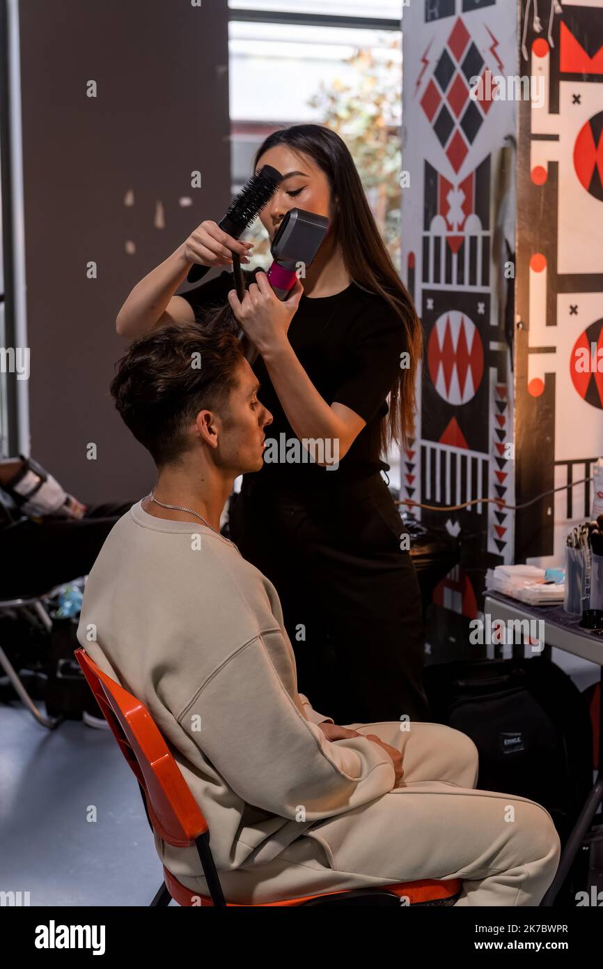 Melbourne, Australia, 14 October, 2022. Back stage a hair stylist puts ...