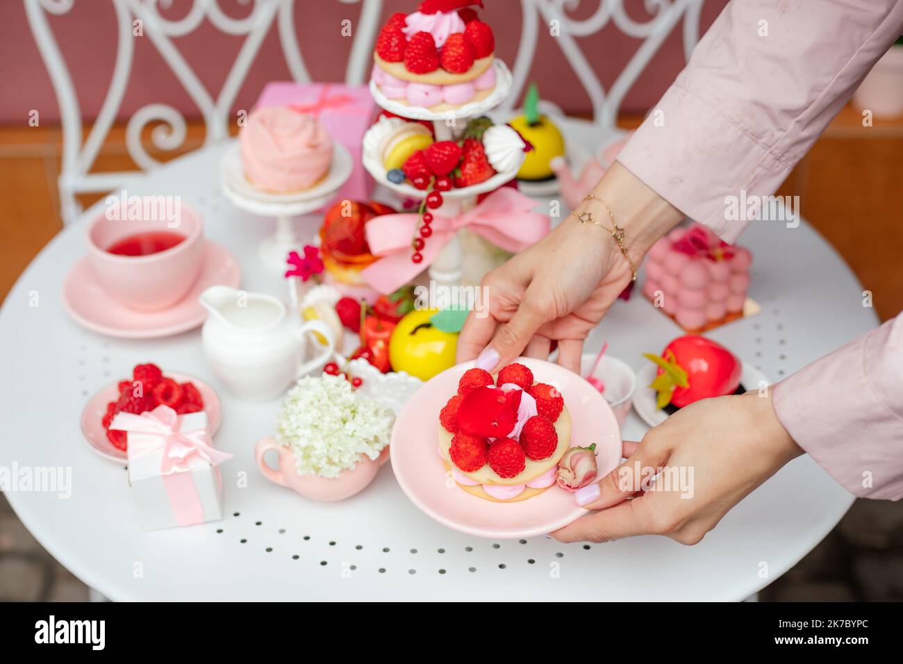 Serving festive table of sweet desserts, fresh strawberry and raspberry ...