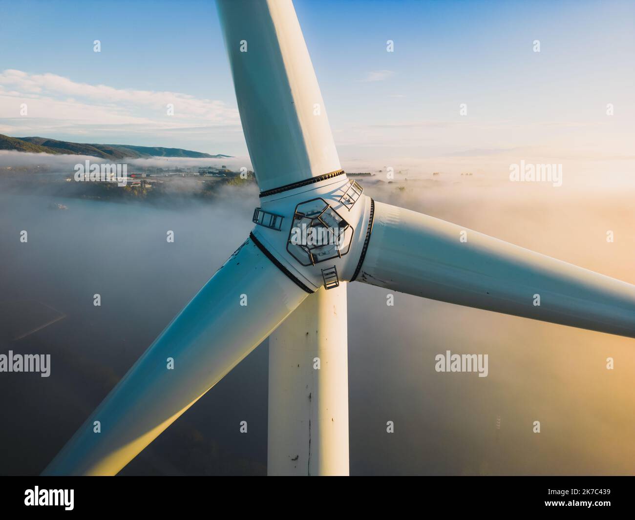 Close-up on the propellers of a wind turbine during a misty morning and ...