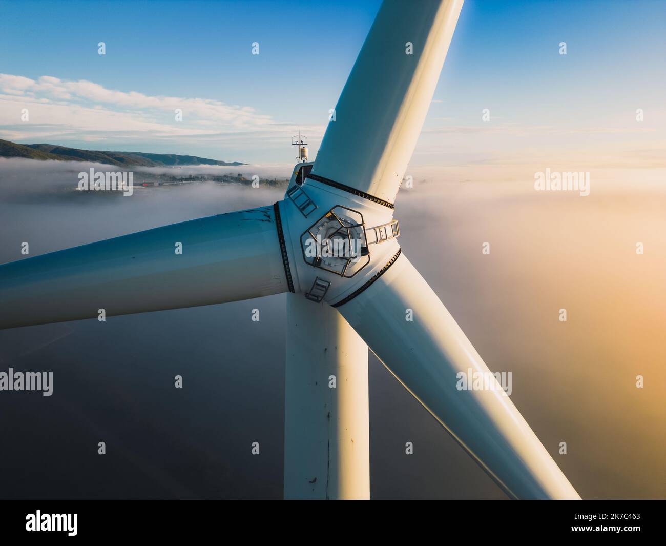 Close-up on the propellers of a wind turbine during a misty morning and ...