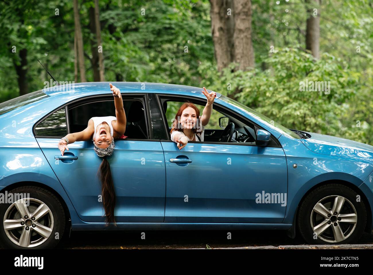 Two girlfriends fool around and laughing together in a car Stock Photo ...