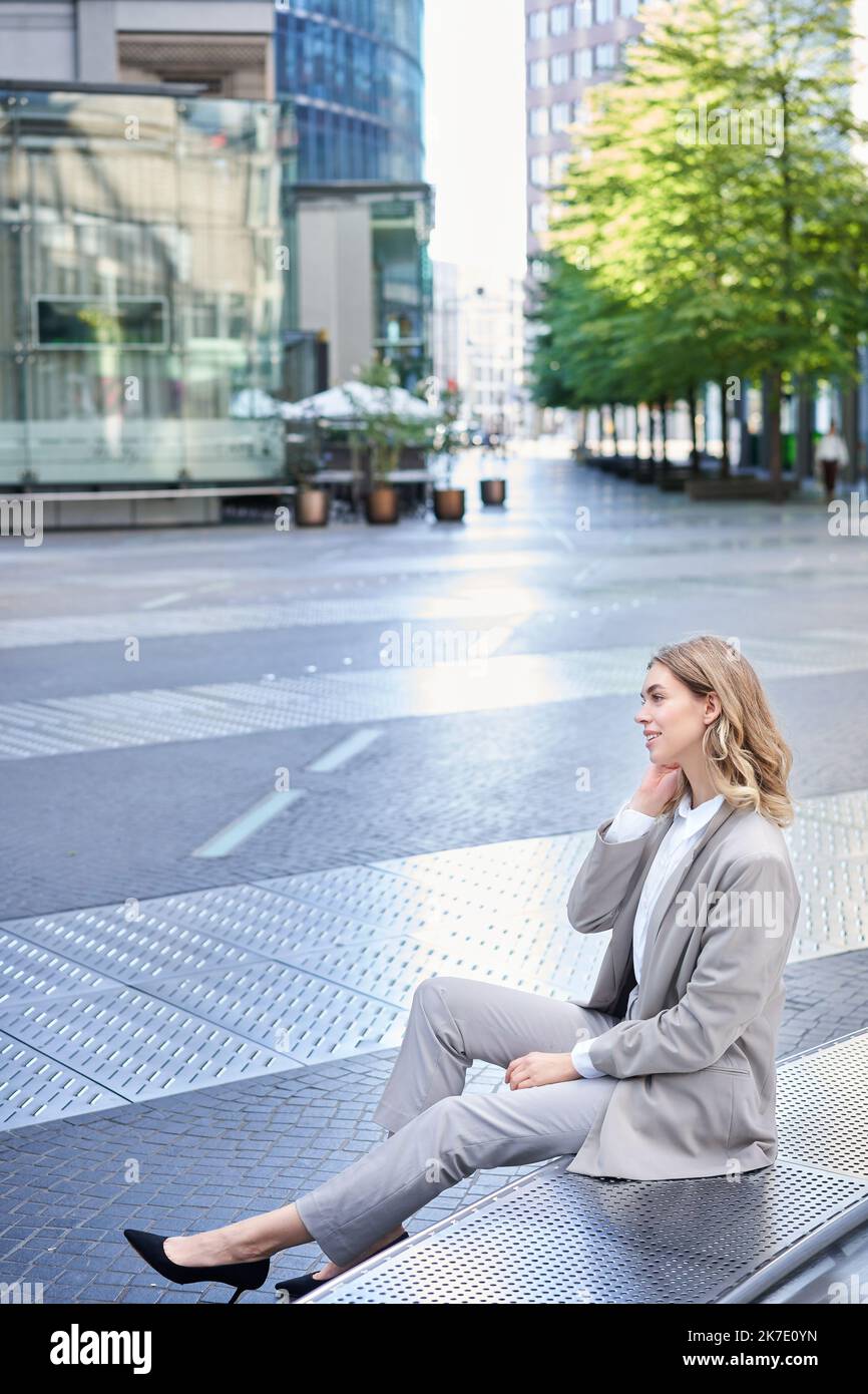 Vertical shot of smiling female entrepreneur in beige suit, corporate ...