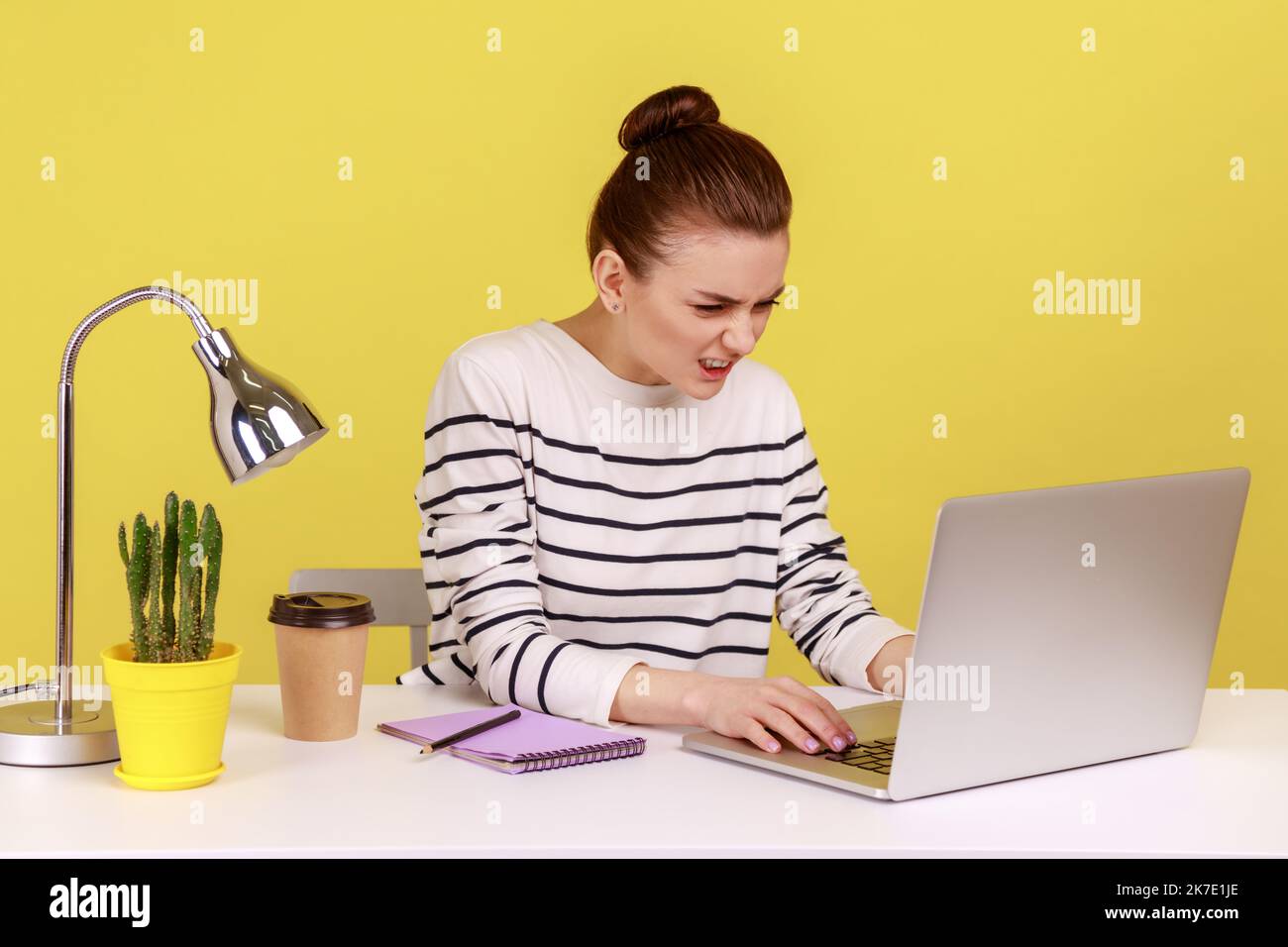 Portrait of woman office manager sitting in front of laptop and typing ...
