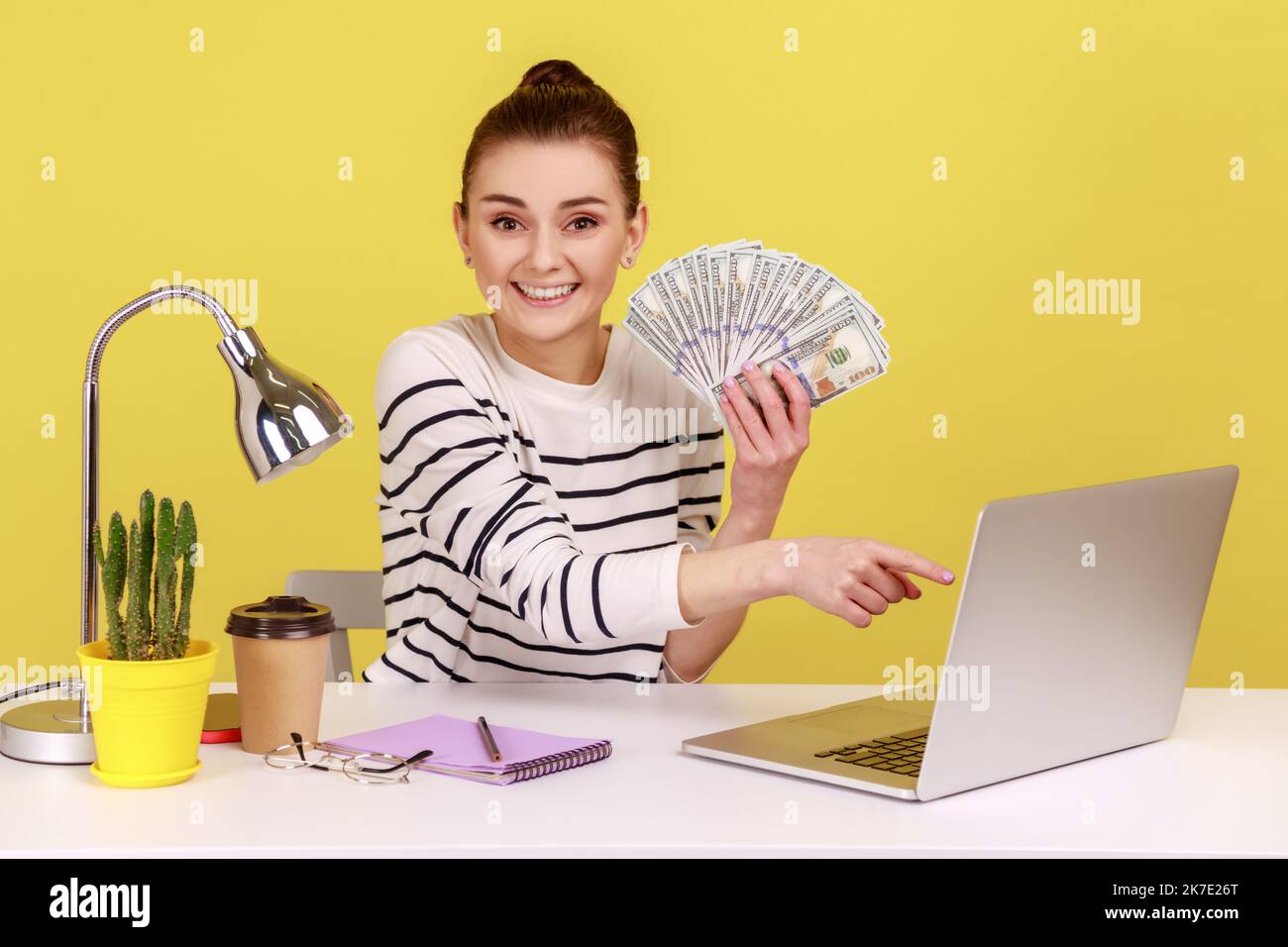 Positive optimistic woman office manager holding fan of dollar ...